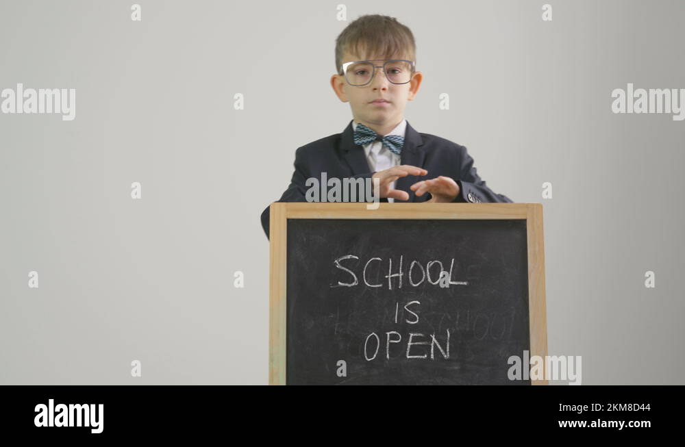 Little student behind blackboard written School is open Stock Video ...