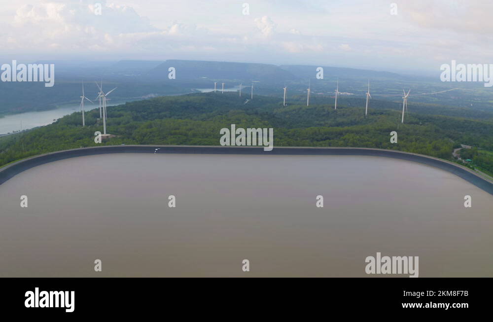 Aerial top view of wind turbines or windmills farm field with water in ...