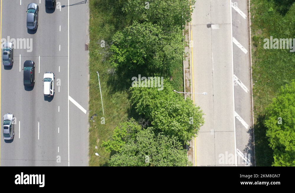 An aerial view directly over a parkway median with green grass and ...
