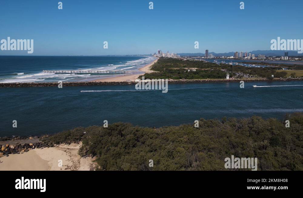 High moving drone view of a busy coastal boating channel with a city ...