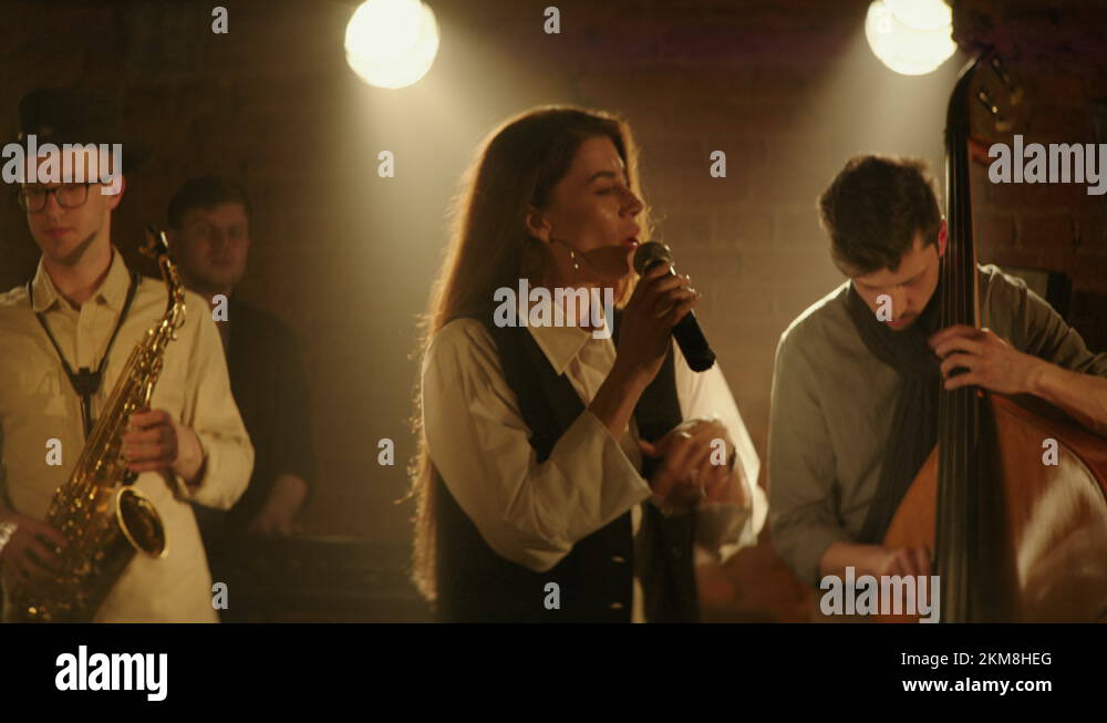 DOLLY OUT People dancing during concert of a modern jazz band playing ...