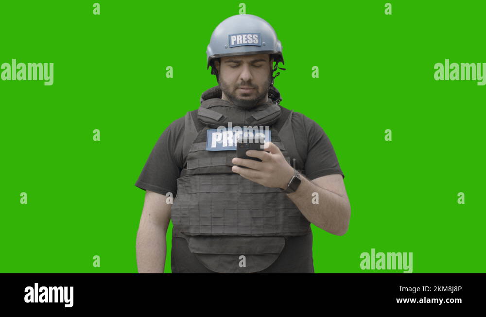 GREEN SCREEN CHROMA KEY War journalist checking updates on his phone ...
