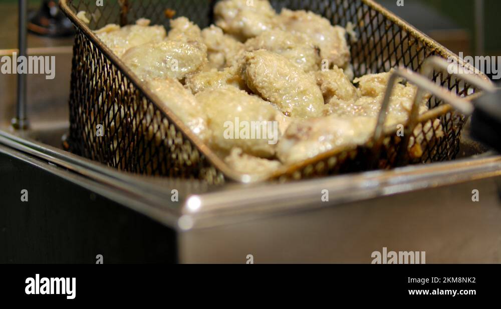Deep frying chicken fritter in oil. Chef in restaurant frying chicken ...