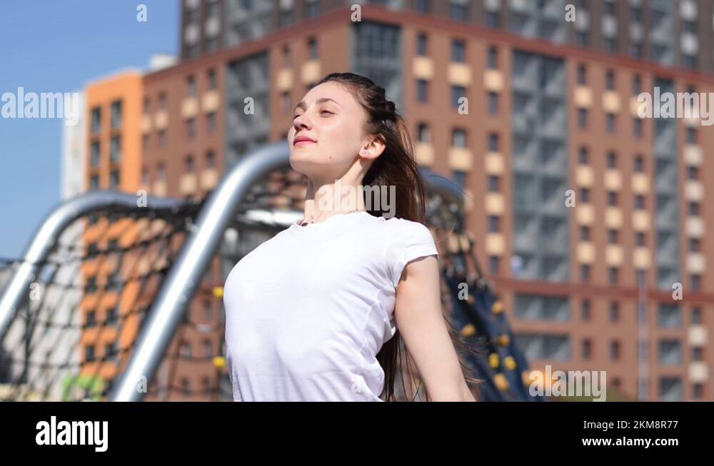 Athletic girl rotates the rope in her hands to warm up the joints of ...