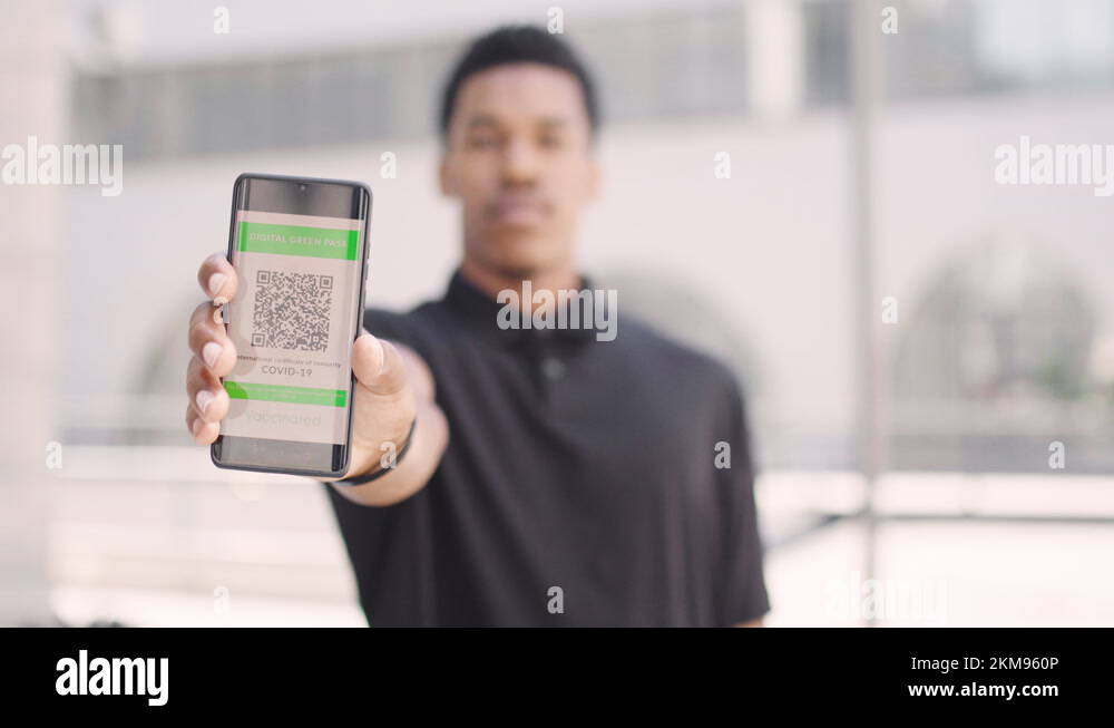 Young African American man showing his digital green pass. Certificate of imm Stock Video ...