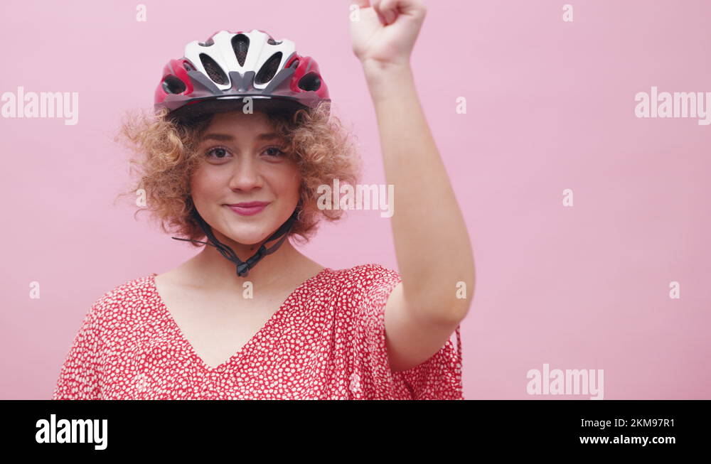 Safety first. Young woman tapping her safety helmet and pointing finger ...