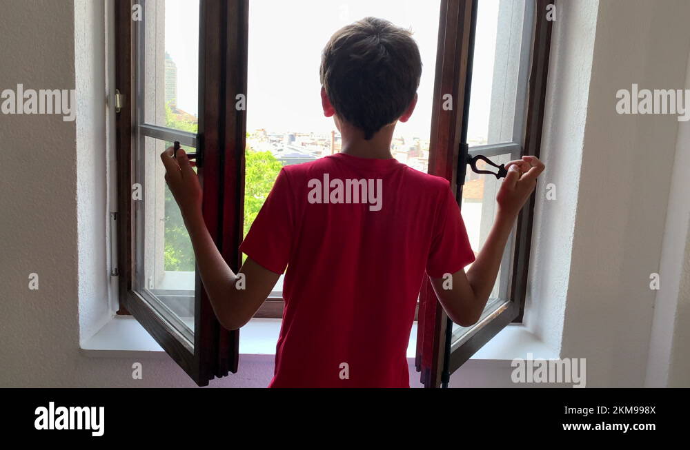 Young boy opening window looking outside. Child opens home windows ...