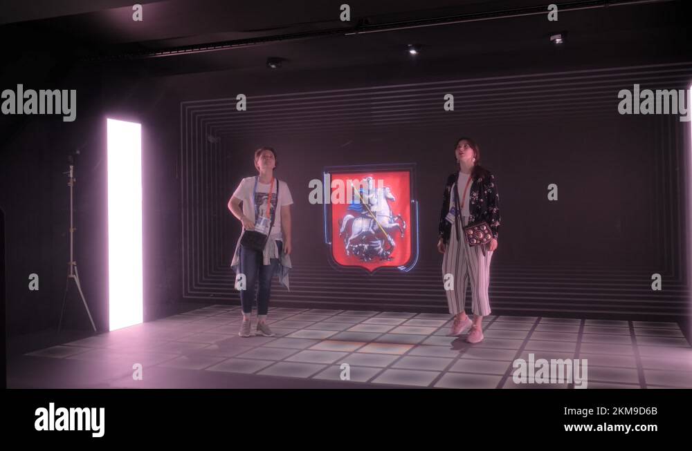 Two women posing with 3D big hologram projection in dark room at AR ...