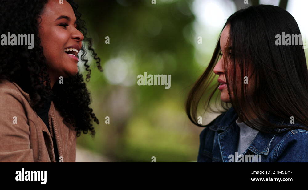 Two friends laughing together, Candid diverse young women real life ...