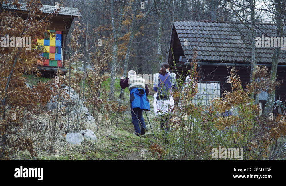Adult daughter and elderly father are hiking together in a rural area ...