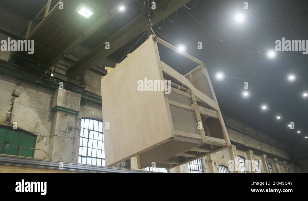 Crane moving large prefab building parts inside warehouse, England, UK ...