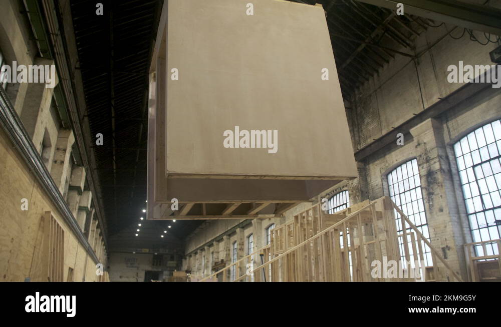 Crane moving large prefab building parts inside warehouse, England, UK ...