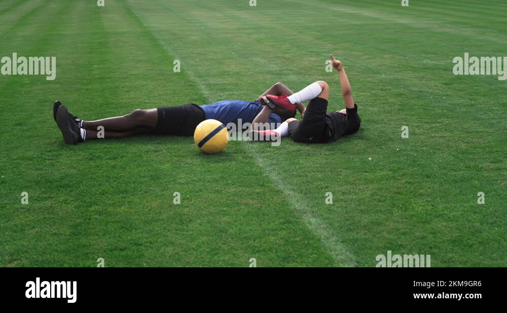 Diverse father and son playing on football pitch during break Stock ...