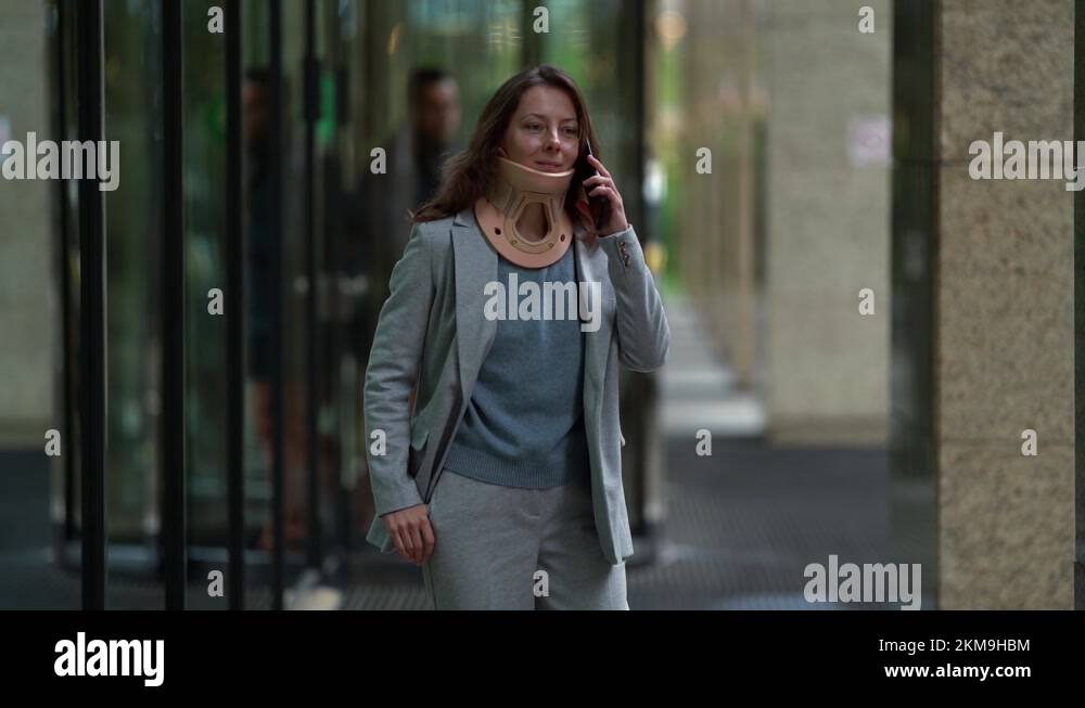 a middle-aged woman with an orthopedic collar around her neck is ...