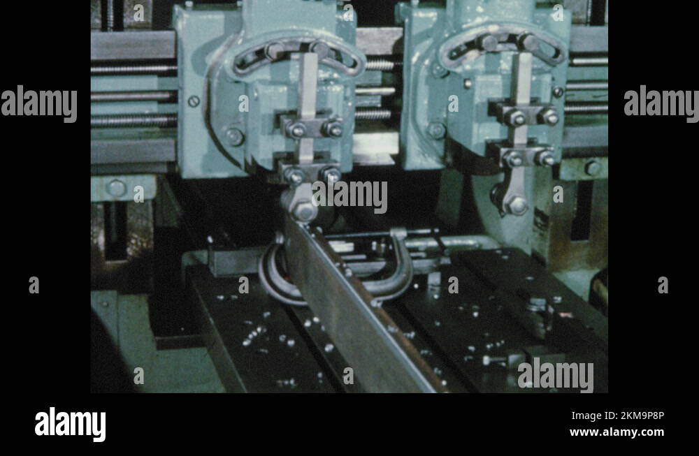 1950s: Man operates metal planer in machining shop. Planer shaves metal ...