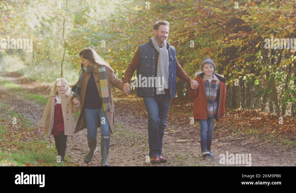 Family With Mature Parents And Two Children Holding Hands Walking Along ...