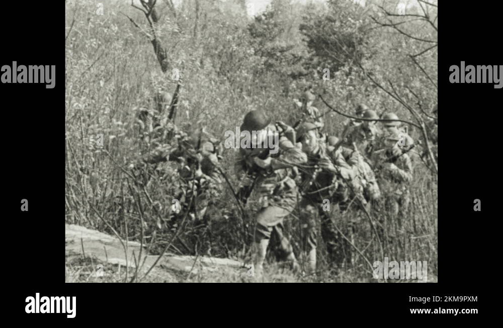 1940s: Soldiers run across field and through underbrush. Men push and ...
