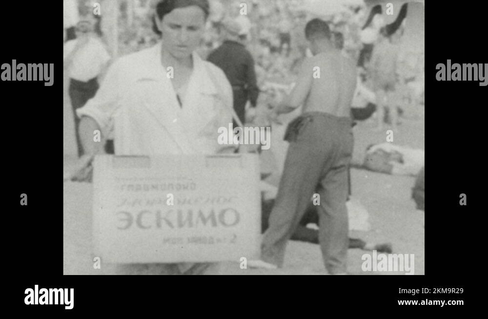 1930s: People crowd on beaches and water. Children dig in sand ...