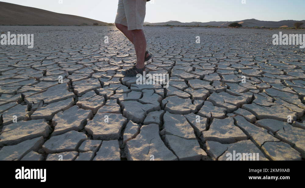 Climate change.Devastated farmer walking across dry dam due to drought ...