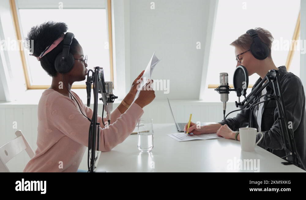 two women in a recording studio creating audio content, recording a ...