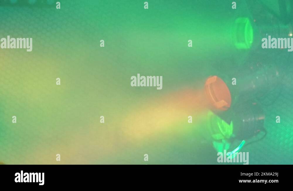 Three classic stage spotlights flash in the green fog under the stage ...