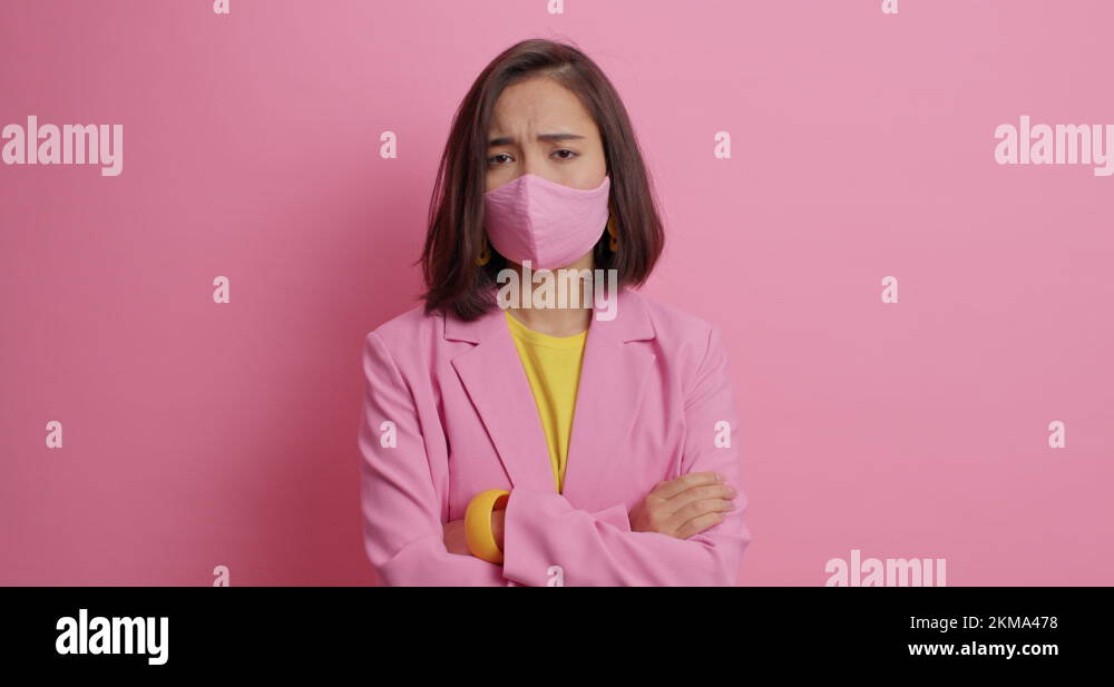 Upset brunette Asian woman with dark hair keeps hands crossed wears ...