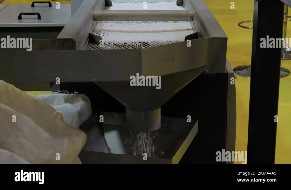 Recycled plastic granules on automatic conveyor belt, shale shaker at ...