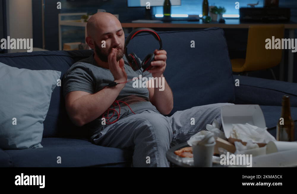 Helpless man with chronic depression putting on headset listening sad ...