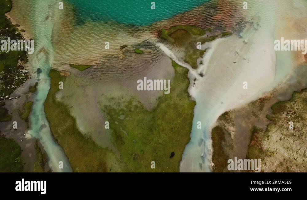 Aerial Looking Down Over End Of River Mouth In Body Of Turquoise Lake ...