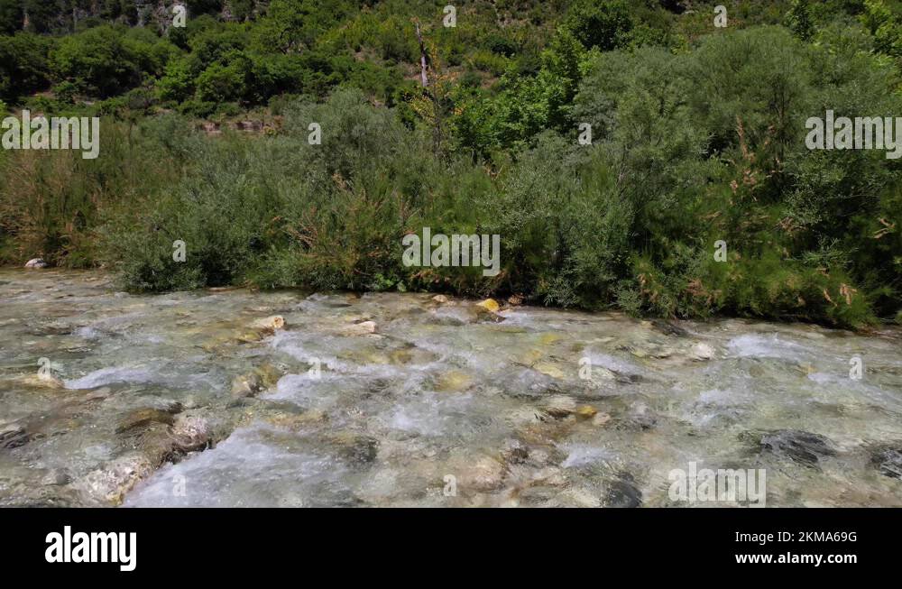 Transparent clean water of river streaming through rocks of riverbed ...