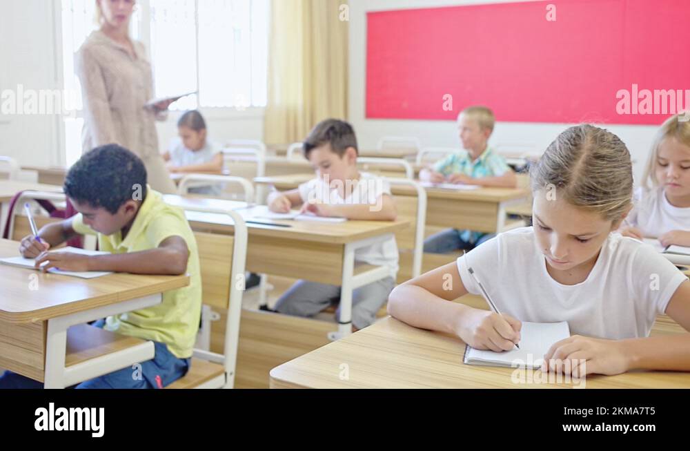 Female teacher controlling learning process in primary school Stock ...