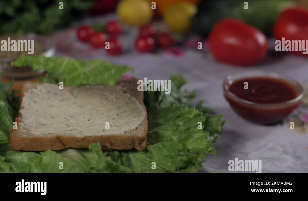Green healthy lettuce leaf falling on a slice of brown bread with ...