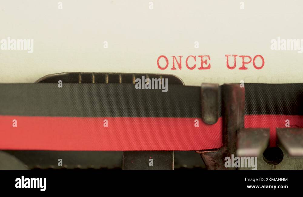 frontal view typing text "once upon a time" on a old typewriter, red ...