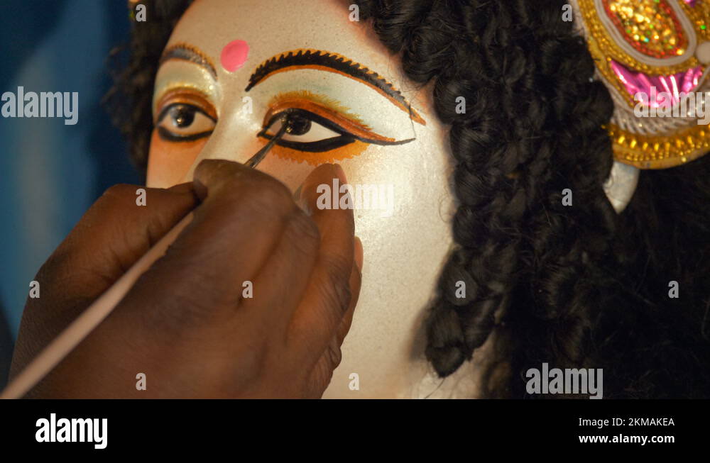 Hands of an Indian artist drawing eyes of the Goddess Durga's clay ...