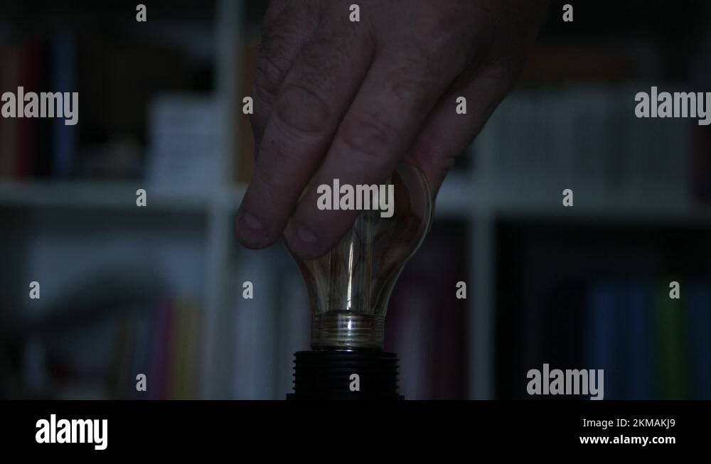 Man Rotates and Unscrew with Hand an Incandescent Light Bulb from His ...