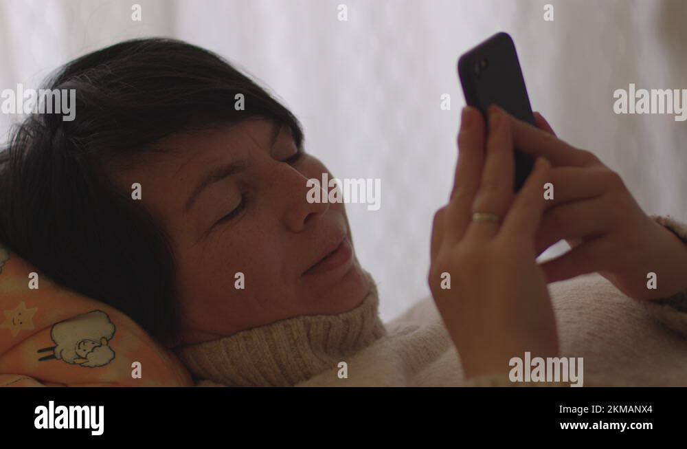 woman uses mobile phone hands lying bed Free time home attention screen ...