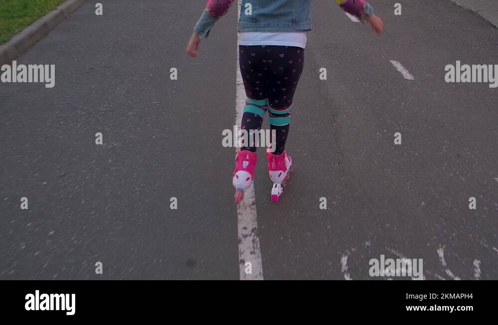 Little girl wearing protection pads and safety helmet learning to ...
