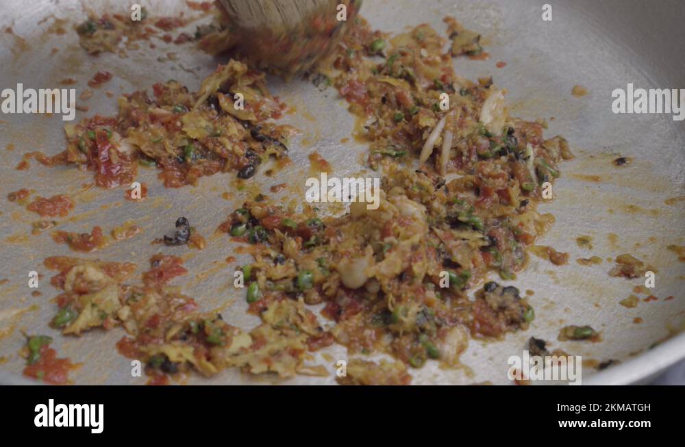 hot chili peppers mashed with pestle in mortar with garlic and ginger ...