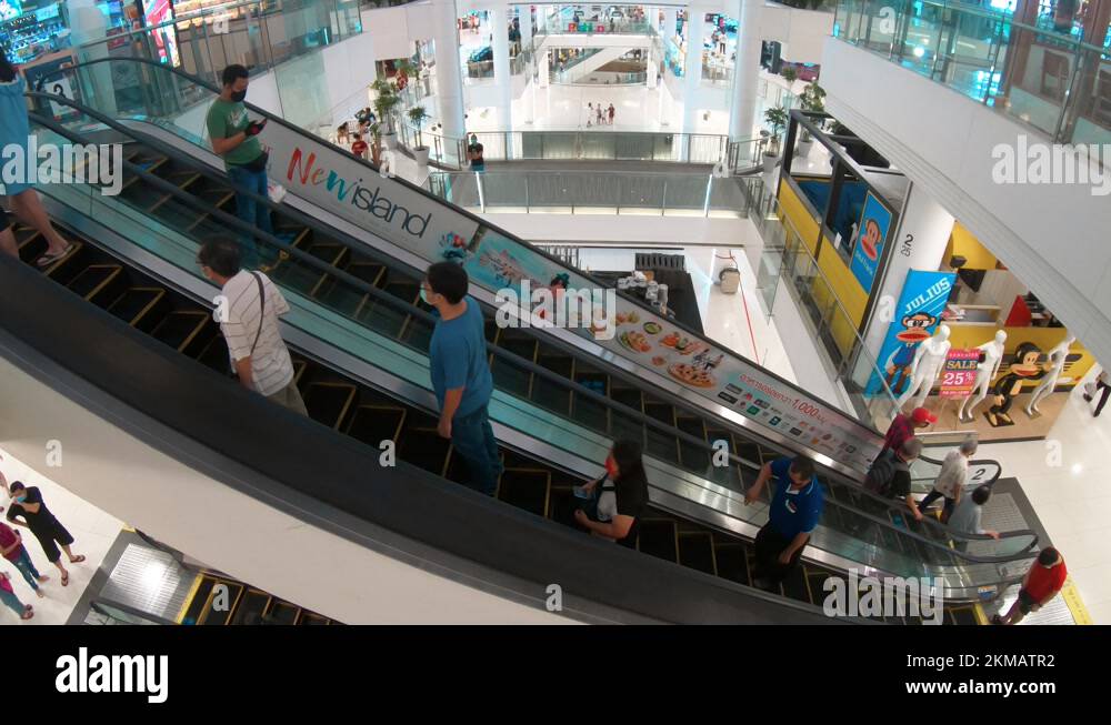 Crowd of people in shopping mall. Escalators in modern shopping mall ...