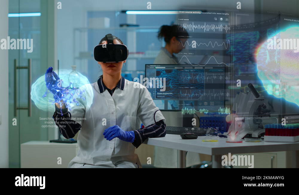 Scientist in lab wearing VR goggles working on augmented reality ...