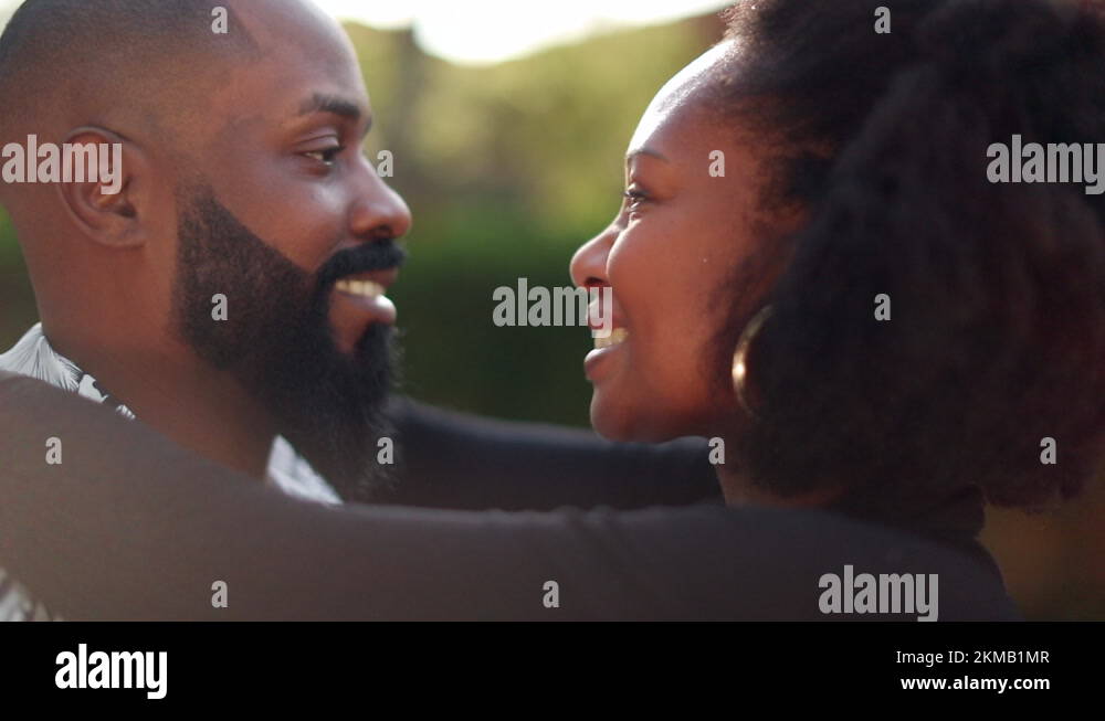 Romantic couple staring at each other outside with lens-flare. Black ...