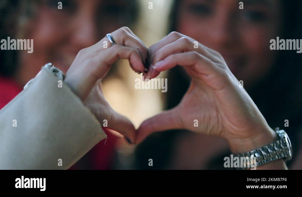 Two girls making heart symbol sign with hands Stock Video Footage - Alamy