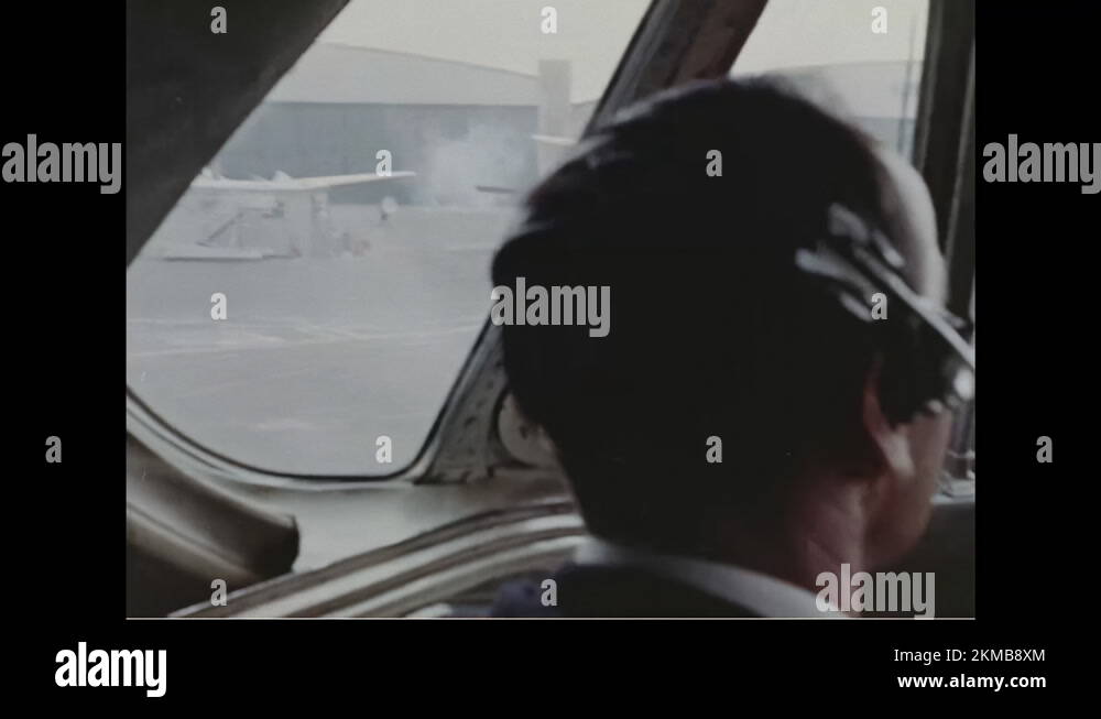 1960s: Pilot in cockpit taxis airplane across tarmac. Tunisian flag ...