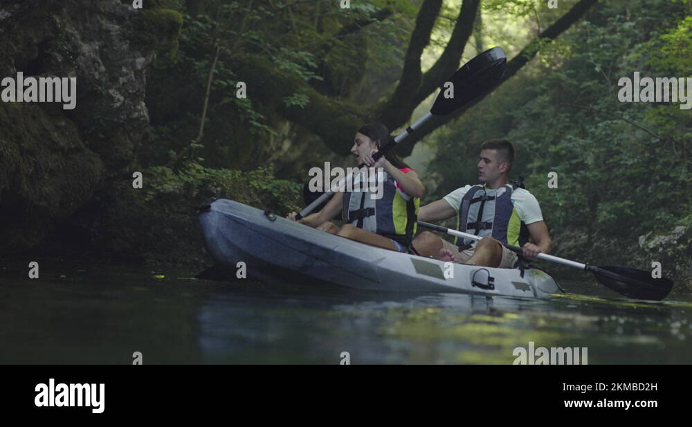 Kayak rowing slow motion. Kayaker woman and man kayaking in a beautiful ...