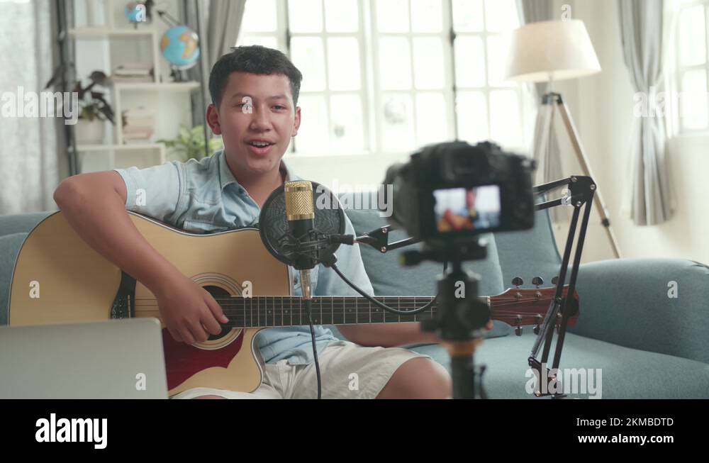 Asian Boy Is A Vlogger.Boy With Guitar Talking To Camera. The Boy Is ...