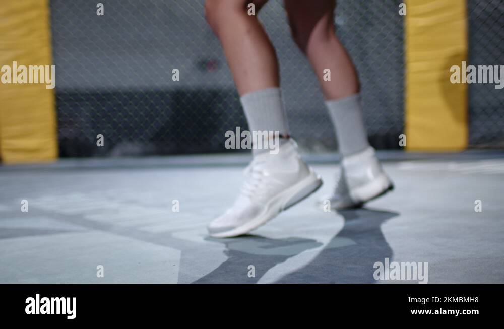 Girl makes punches. Girl moving her feet during the octagon fight ...