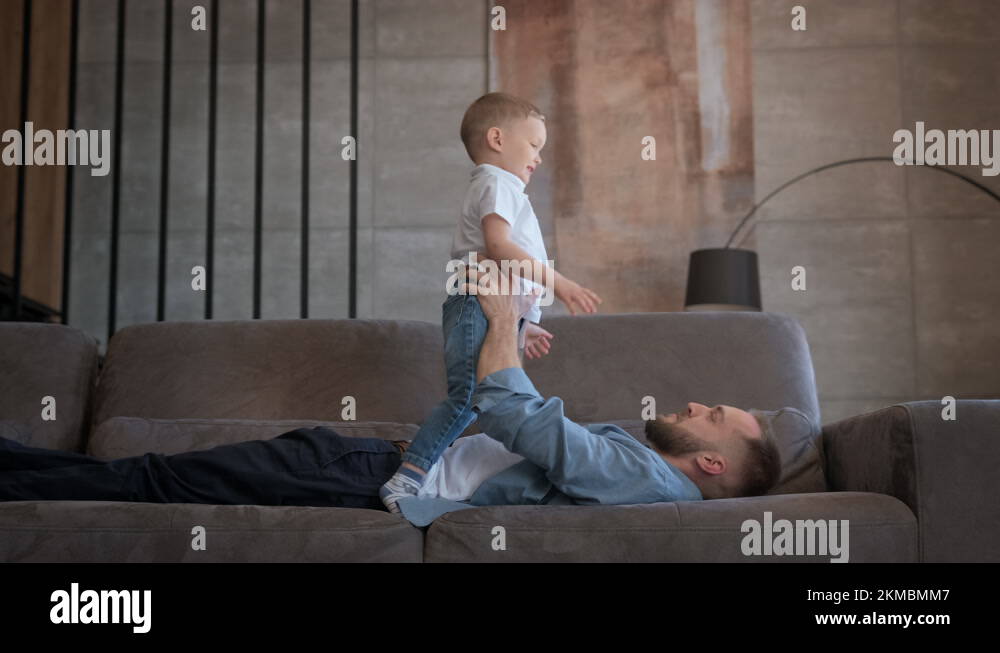 Slow motion happy family daddy lifts little boy to fly like plane ...
