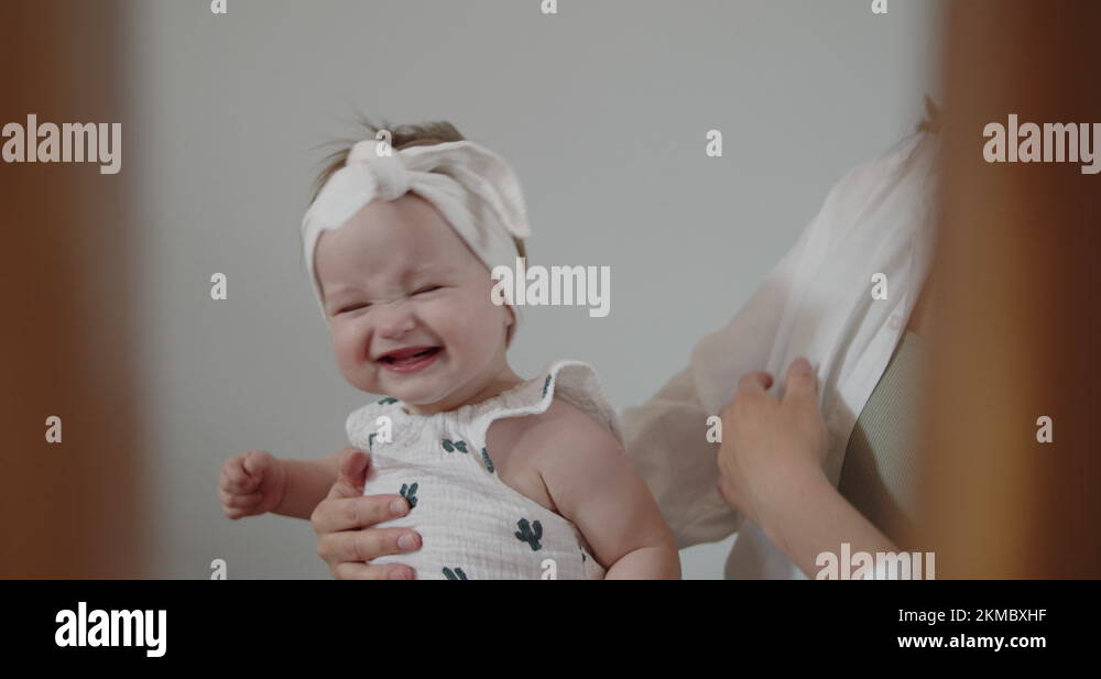 Cheerful baby girl laughing and dancing sitting on mother's knees Stock ...
