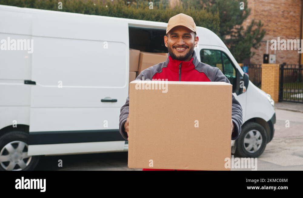 Delivery boy Holding A Parcel Moving The Box Towards The Camera Parcel ...