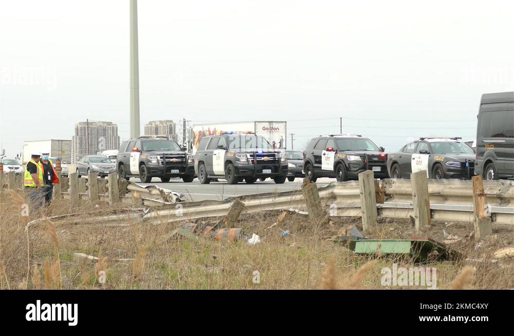 Group of police vehicle at highway crash scene with broken side fence ...
